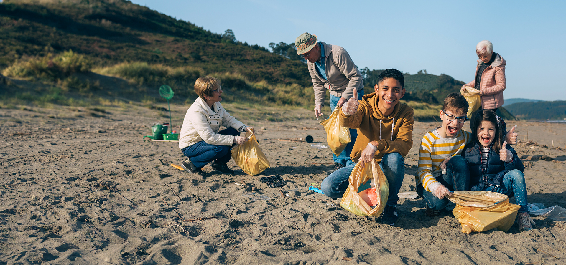 Young man and children cleaning the beach - Save the Sound